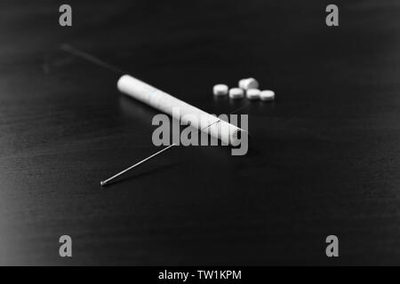 Acupuncture needles with cigarette on dark background Stock Photo - Alamy