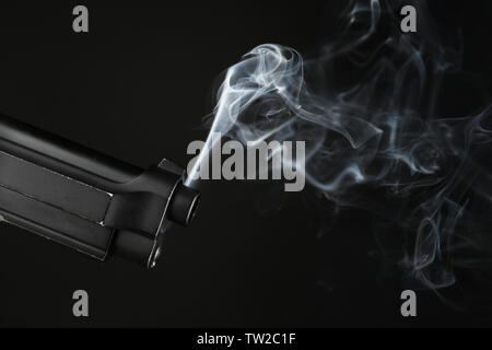 Smoking gun on black background Stock Photo - Alamy