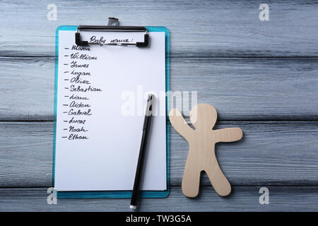 Clipboard with list of baby names and wooden letters on light blue ...