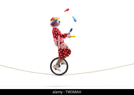 Clown as juggler is balancing on rope Stock Photo - Alamy