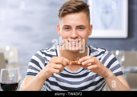Young man eating delicious ribs in restaurant Stock Photo - Alamy