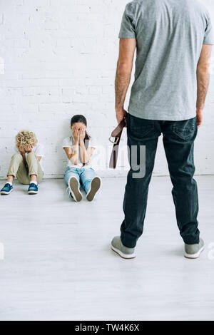 cropped view of father with belt and crying son at home Stock Photo - Alamy