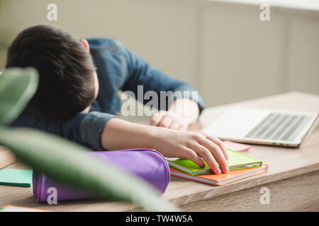 Child sleeping near notebooks and laptop on table at home, banner Stock ...