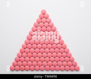 Triangle made of pills on white background Stock Photo - Alamy