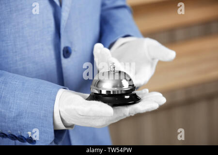 Man holding bell on blurred background, closeup Stock Photo - Alamy