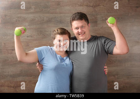 Overweight couple training together on wooden floor Stock Photo - Alamy