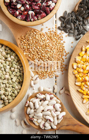Different grains in kitchenware on wooden background Stock Photo - Alamy