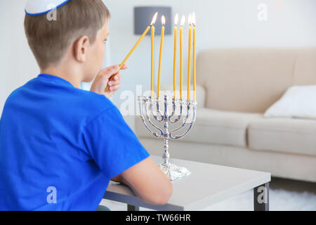 Jewish boy lightning menorah at home Stock Photo - Alamy