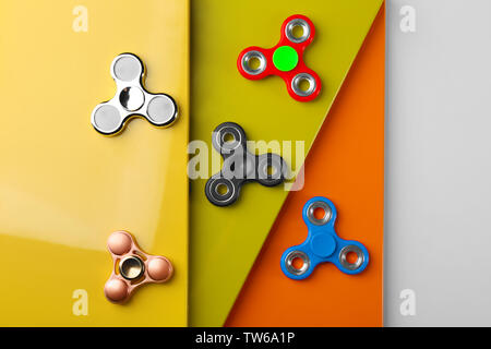 Different modern spinners on colorful background, top view Stock Photo ...