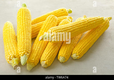 Fresh corn cobs on light background Stock Photo - Alamy