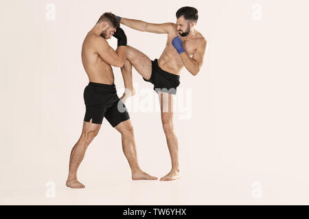 Male kickboxers fighting on white background Stock Photo - Alamy
