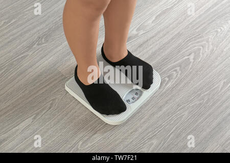 Overweight boy standing on scales against white background Stock Photo ...