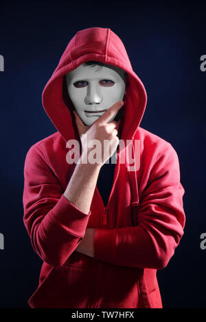 Masked hacker wearing hoodie in darkness Stock Photo - Alamy