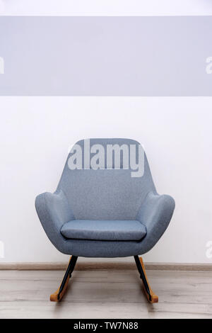 Modern rocking chair near a light wall Stock Photo - Alamy