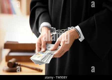 Male judge in handcuffs holding bribe, closeup Stock Photo - Alamy