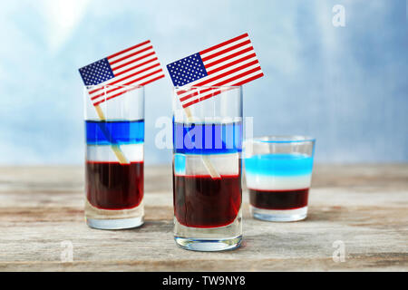 Layered alcoholic cocktails, on a wooden board on a black background ...
