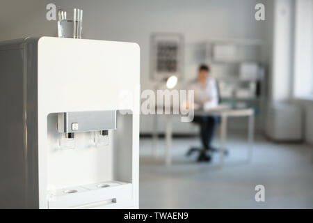 Modern water cooler in office Stock Photo - Alamy