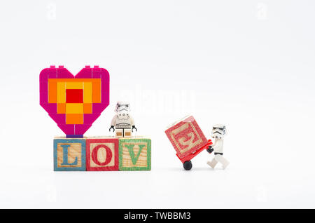 lego stormtrooper sitting on word love with piece offering heart shape ...