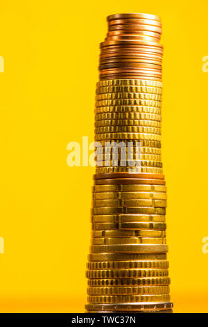 Stack of euro coins in a yellow background Stock Photo - Alamy