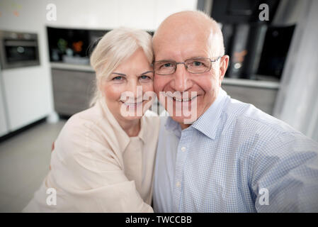 Cheerful couple taking selfie, comfortable interior in domestic bedroom ...