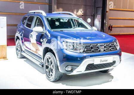 a blue dacia duster SUV car driving along an unmade stone track road ...