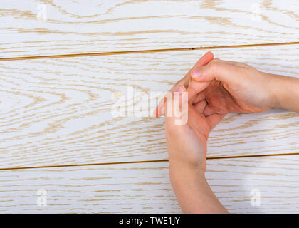 Hand making a gesture on a wooden background Stock Photo - Alamy