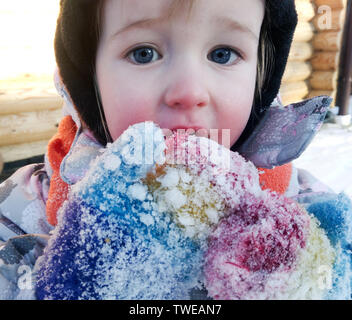 Winter girl eating snow outdoor. Funny christmas kids lick snow with ...