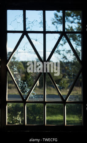 cracked and broken window glass punched by a pistol bullet Stock Photo ...