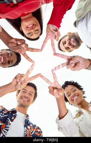 People forming star shape with their fingers against the backdrop of a ...