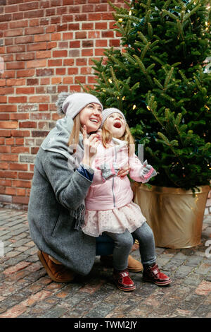 Mother with her child daughter celebrating near Christmas tree Stock ...