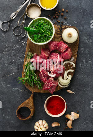 Raw piece of meat for grilling with vegetables in a cast iron pan ...