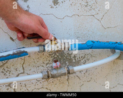 Hand using an old rusty faucet on a pipe outside Stock Photo - Alamy