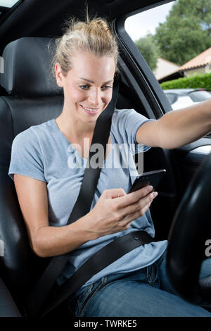 Distracted careless young woman texting while driving a car, isolated ...