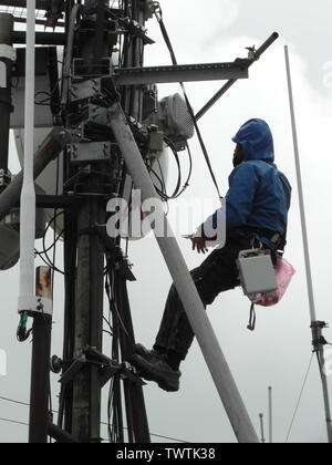 Telecom tower climber working on top of radio tower installing a ...