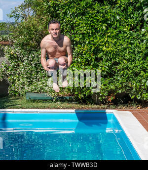 Caucasian man takes a bomb dive in the pool Stock Photo - Alamy