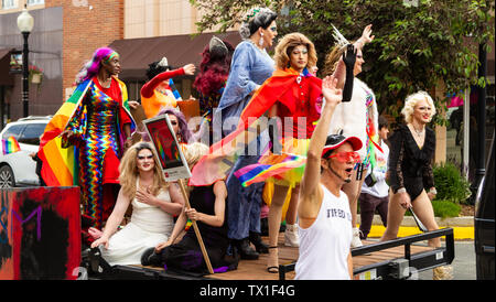 A float of drag queens wearing rainbow colors and showing their pride ...