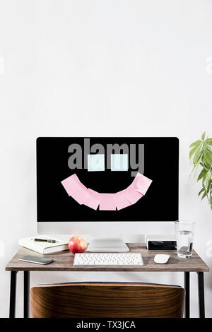 Smiley face on an adhesive note on computer monitor Stock Photo - Alamy