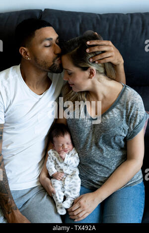 Cuddling on the couch. at affectionate couple relaxing on a sofa at ...