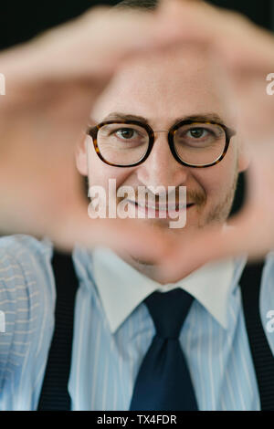 Portrait of a businessman making a finger frame Stock Photo - Alamy