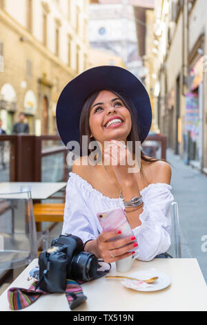 Italy, Florence, portrait of happy young tourist with camera and ...