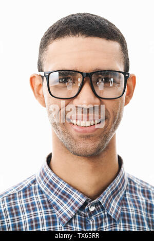 Young man wearing glasses over yellow background looking at the camera ...