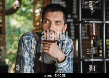 Image of caucasian barista boy wearing apron making coffee while ...