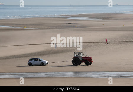 Car stranded on sandy beach at Wissant in northern France being towed ...