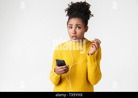 Image of nice puzzled woman with curly red hair holding cellphone and ...
