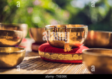 Tibetan singing bowls on a straw mat against a waterfall BANNER, LONG ...