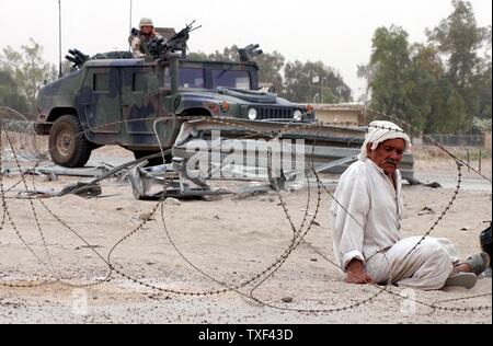 Iraqis wait at a checkpoint outside Fallujah, Iraq on April 29, 2004 ...