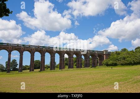 Balcombe Ouse Valley Viaduct with train crossing over the top. A man ...