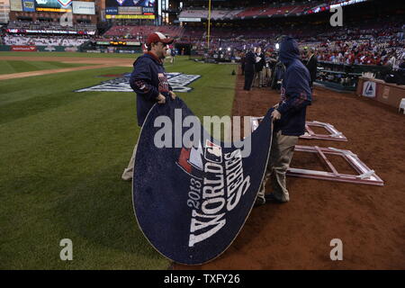 A Boston Red Sox ground crew worker carries a stencil towards the ...
