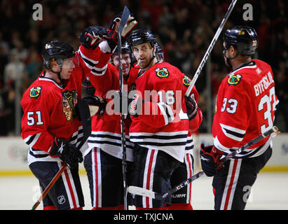 Chicago Blackhawks' Brian Campbell, left, takes a hit from Calgary ...