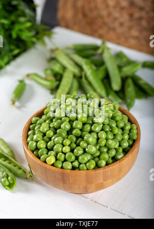 Green peas in wooden bowl on wooden background Stock Photo - Alamy